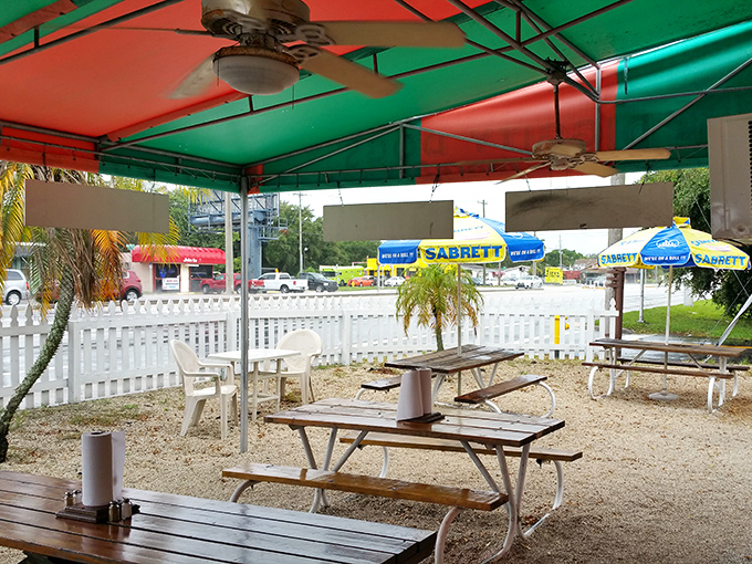 The outdoor seating area's red and green canopy creates a festive atmosphere. Those Sabrett umbrellas are practically waving you in.
