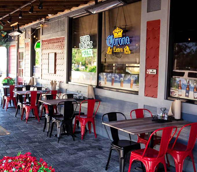 Red chairs pop against industrial-chic walls on the patio. Florida dining that lets you enjoy both AC and sunshine.