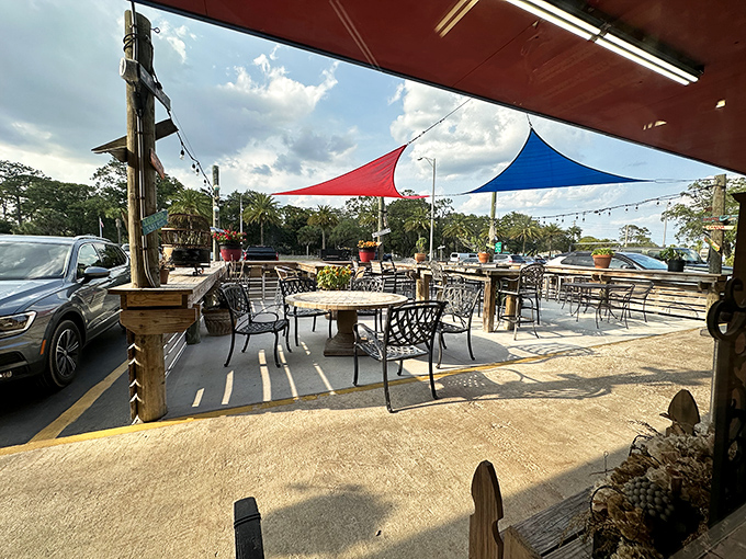 The outdoor patio offers fresh air dining with colorful umbrellas creating the perfect beachside lunch atmosphere.