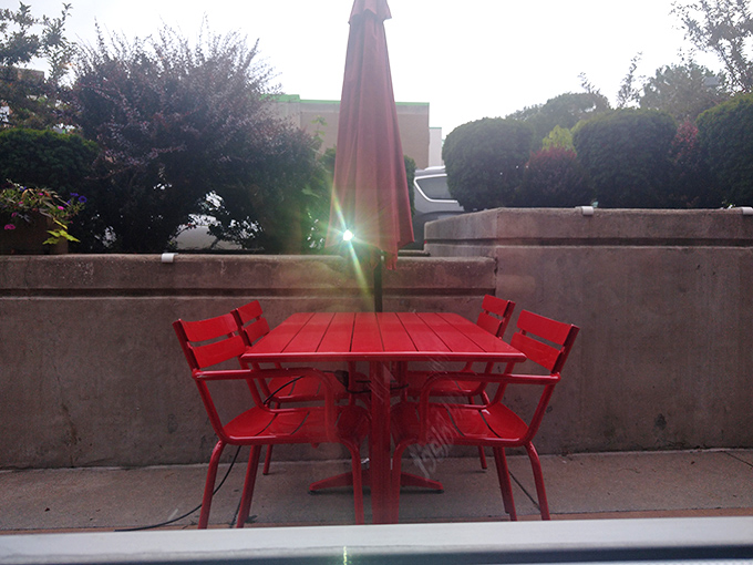 The outdoor patio's bright red furniture says, "Coffee tastes better in sunshine." A little al fresco with your frittata, perhaps?