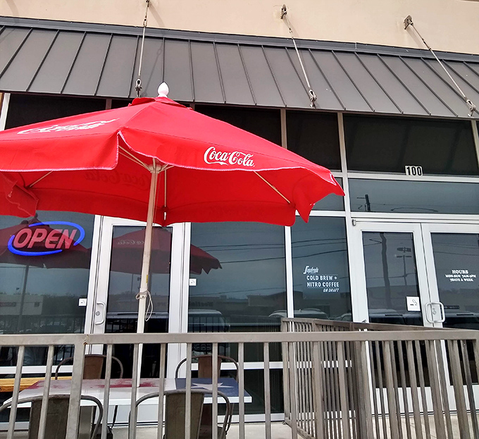 The patio welcomes early birds with Coca-Cola umbrellas and the promise of coffee refills while watching the world wake up.