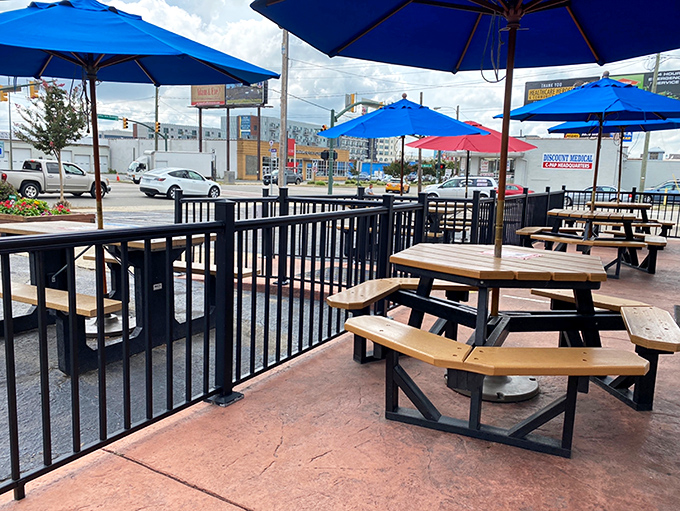 Outdoor dining that invites lingering. Those blue umbrellas aren't just for shade—they're signals that summer afternoons were made for burgers and conversation.