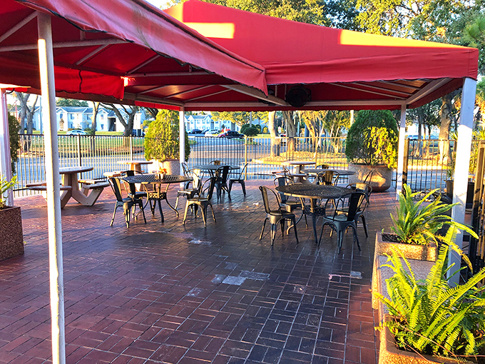 The outdoor patio&mdash;where Florida sunshine meets New England flavors. Those red awnings aren't just for shade; they're setting the stage for seafood theater.