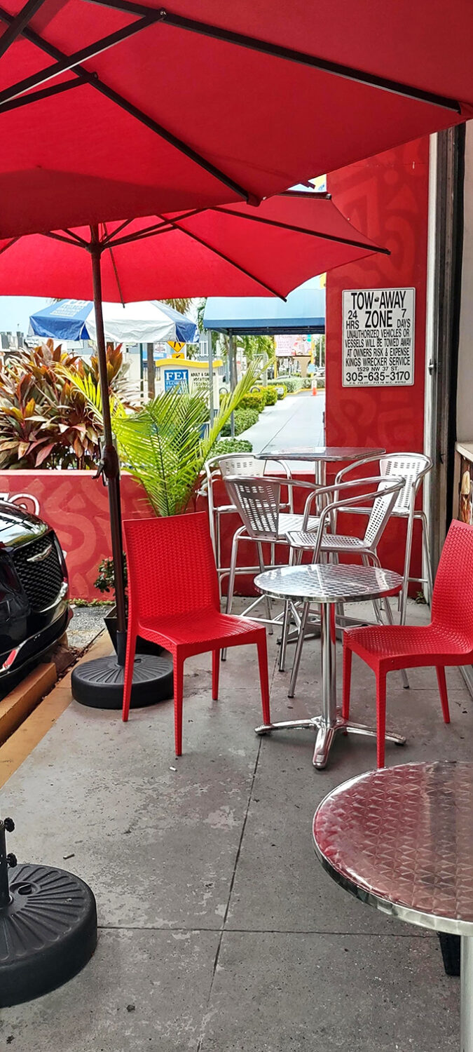 Sidewalk seating under Miami's endless summer sky. Even parking signs look poetic when anticipating flavors this good.