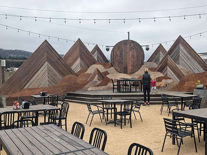 Outdoor dining with artistic flair - these wooden mountains create the perfect backdrop for conversations that wander pleasantly, just like coastal highway drives.