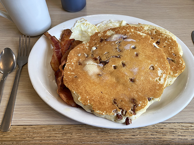 Chocolate chip pancakes with perfectly cooked bacon—the breakfast that makes you understand why morning people are so annoyingly cheerful.