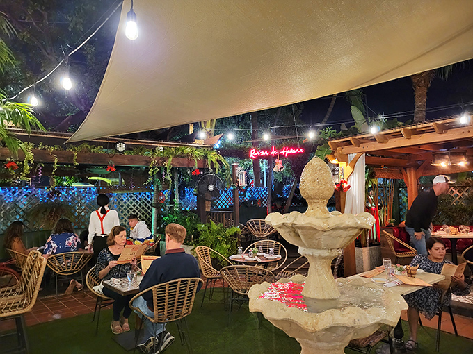 The outdoor patio offers a tropical escape where fountain sounds and string lights create the perfect backdrop for evening enchantment.