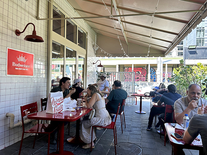 Outdoor seating where Miami's sunshine becomes the perfect condiment. Those red tables create a cheerful backdrop for serious eating.
