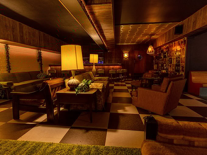 The lounge area looks like it was plucked straight from a 1960s living room, complete with vintage furniture, checkered floor, and lamps that have witnessed decades of celebrations.