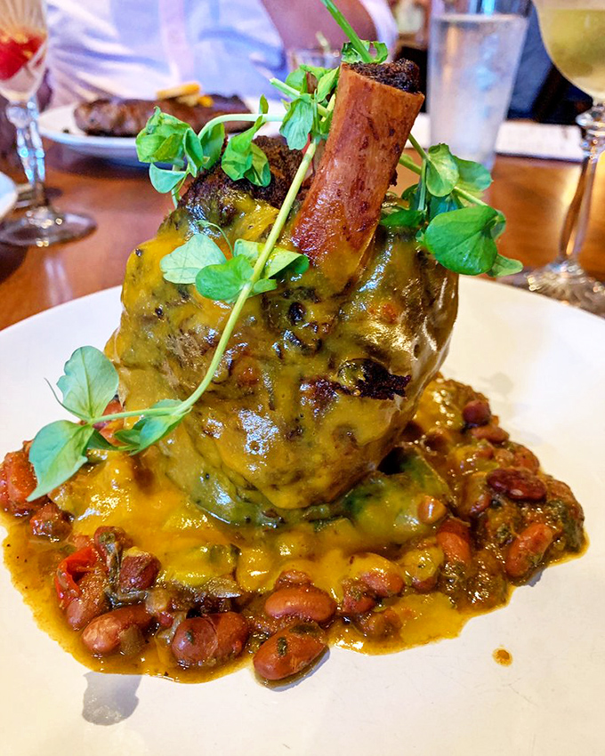 This isn't just a pork shank&mdash;it's architecture with sauce. Standing tall above a bed of beans, it's the Leaning Tower of Pork that demands both a photo and your full attention.