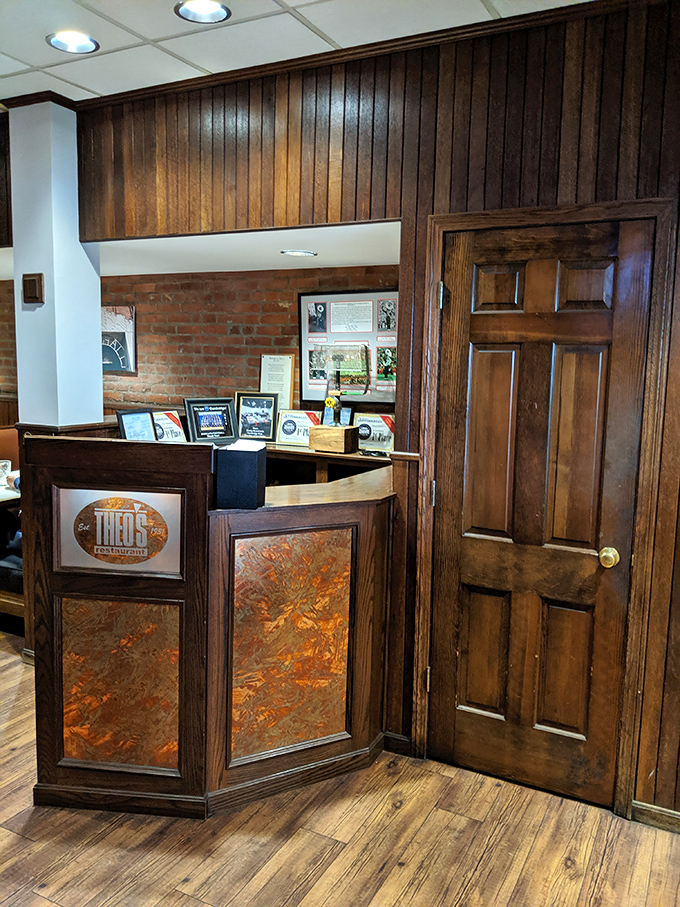 The reception area's warm wood tones and brick walls speak to Theo's heritage, a restaurant that values tradition without feeling stuck in the past.