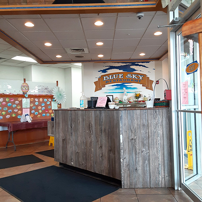 The reception area welcomes with rustic wood paneling and that signature blue sky logo—your first hint that this isn't just another roadside eatery.