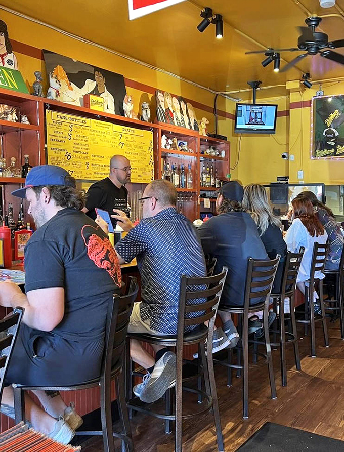 The bar area hums with anticipation as patrons perch on stools, waiting for their chance at hot dog nirvana.