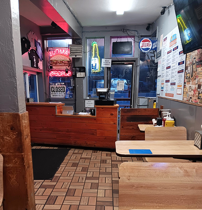 The ordering counter glows with neon nostalgia. Behind that wooden counter, burger magic happens with practiced precision and zero pretension.