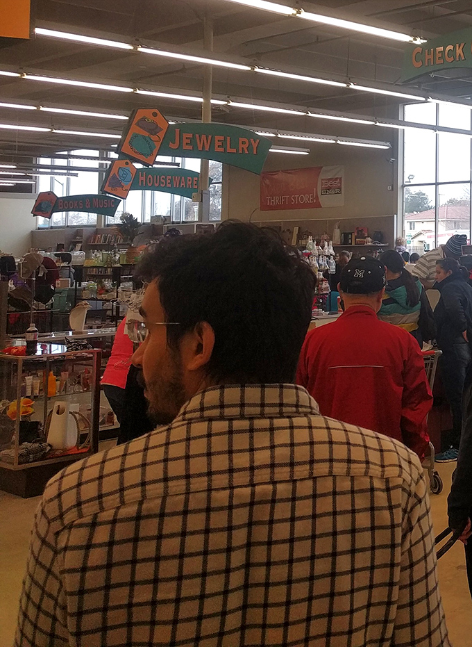 Fellow treasure hunters navigate the aisles with shopping carts full of possibilities and hopeful discoveries.