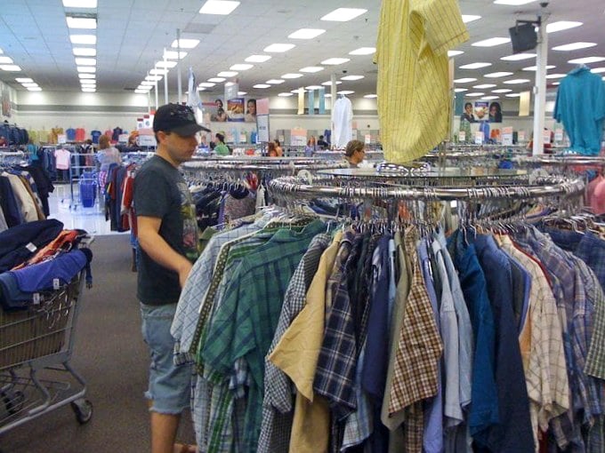 The thrill of the hunt captured in action! This shopper navigates the plaid archipelago with the focused determination of a seasoned treasure hunter.