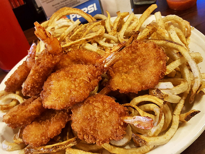 Crispy golden shrimp nestled among curly fries – proof that sometimes the best seafood comes from the most unexpected places.