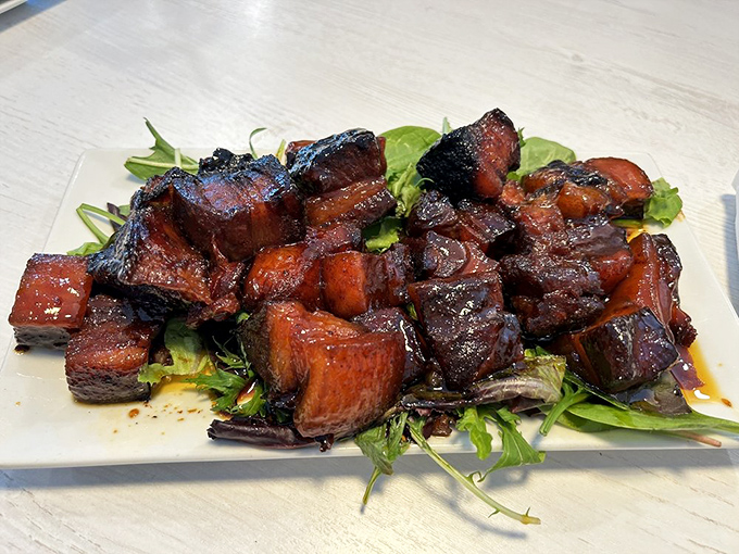 Burnt ends that redefine indulgence. These glistening cubes of smoked pork belly are like meat candy for grown-ups, served atop fresh greens for "balance."