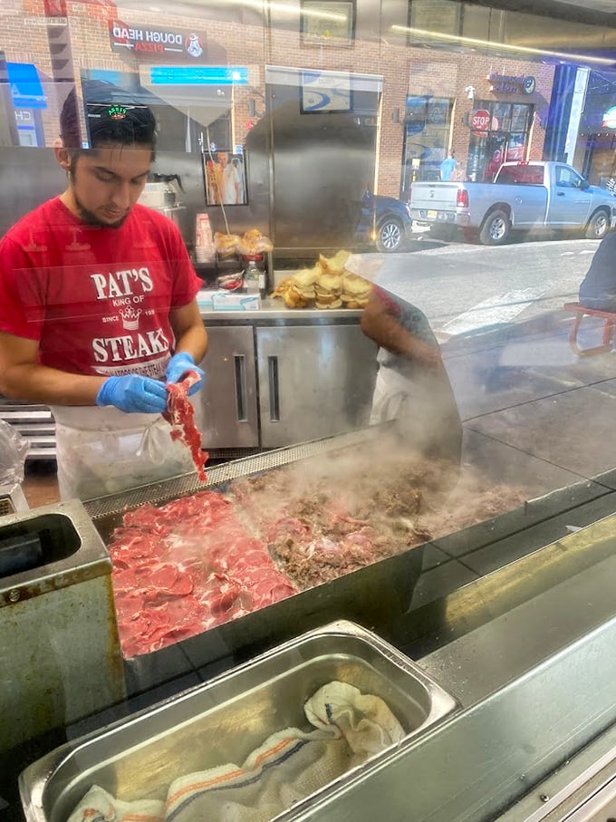 Slicing, chopping, creating&mdash;the sacred ritual of cheesesteak preparation unfolds. Those blue-gloved hands hold the culinary fate of dozens.