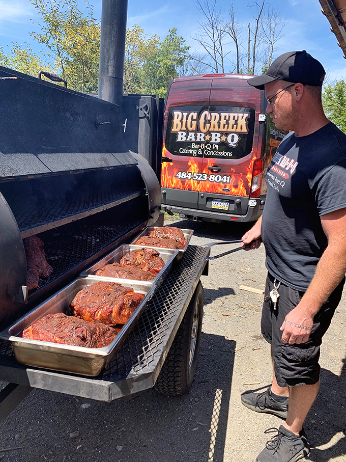 The pitmaster at work, tending to his craft. That focused expression says everything about the care going into your meal.