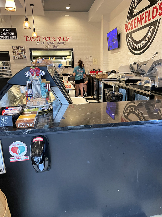 Behind the counter, where sandwich magic happens. The display case showcases New York deli classics with Delaware beach attitude.
