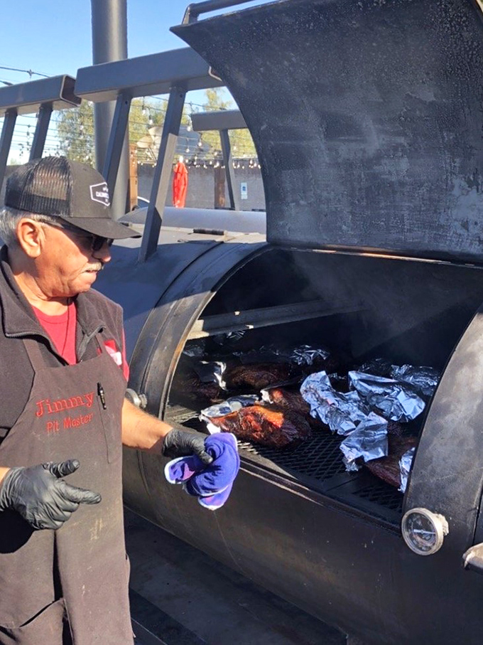 The pitmaster at work, tending to meat with the focus of a surgeon and the patience of a saint. BBQ is science, art, and religion all at once.
