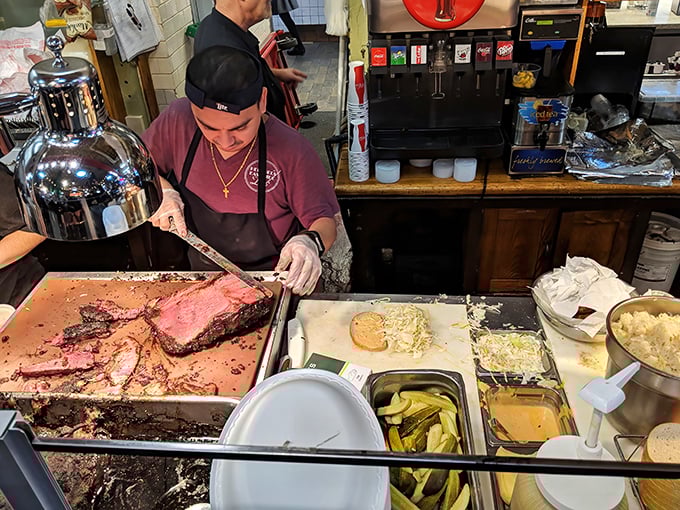 The silent concentration of a deli artist at work. Carving meat isn't just a job; it's a performance deserving of a standing ovation.