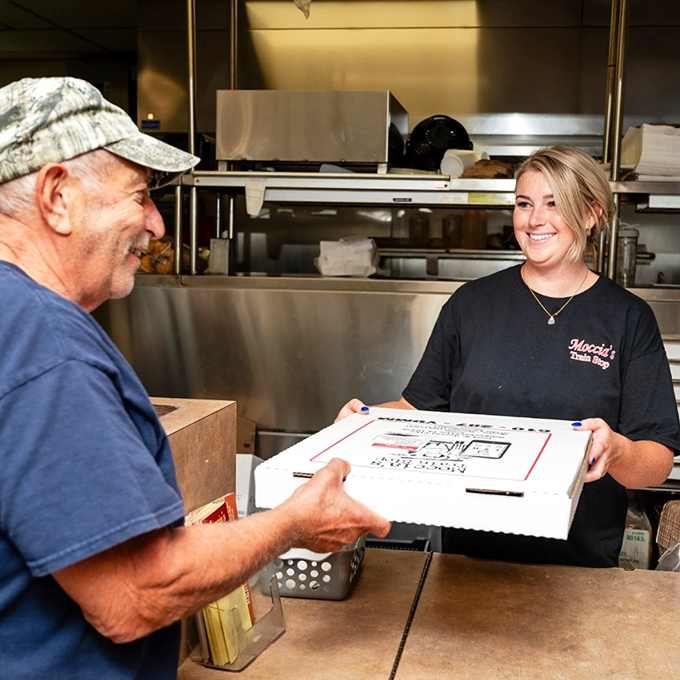 The pizza handoff&mdash;that magical moment when fresh-baked goodness begins its journey from kitchen to grateful customer.