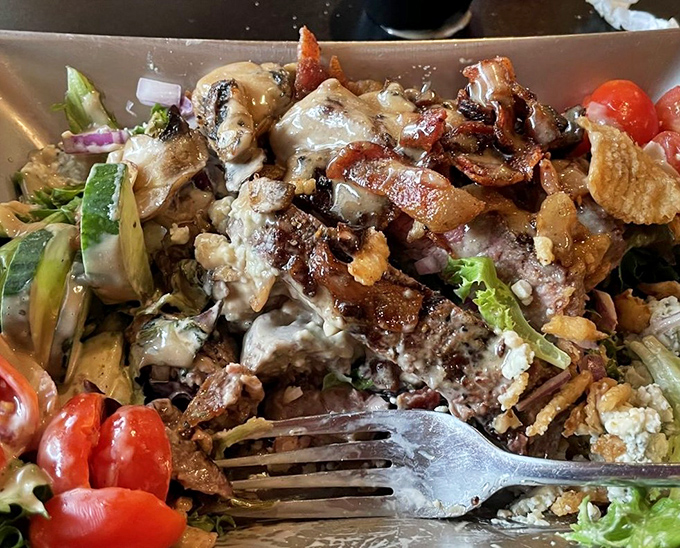 A salad that carnivores can love. Perfectly cooked steak, crisp vegetables, and what appears to be bacon create a protein-packed masterpiece that satisfies deeply.