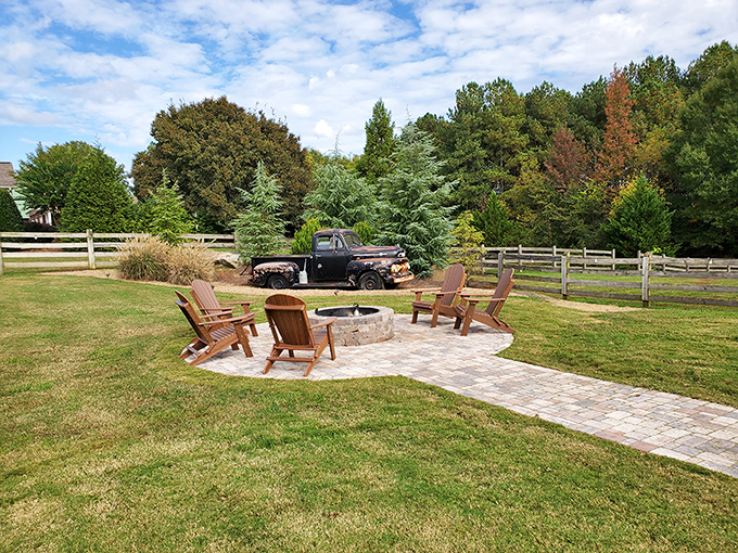 A perfect fire pit circle surrounded by Adirondack chairs—where summer evenings turn into memories and marshmallows meet their delicious doom.