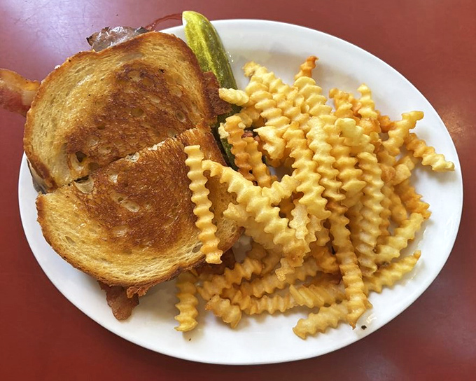 Not just a sandwich but an architectural achievement&mdash;golden toast supporting a tower of deliciousness with crinkle fries standing guard.