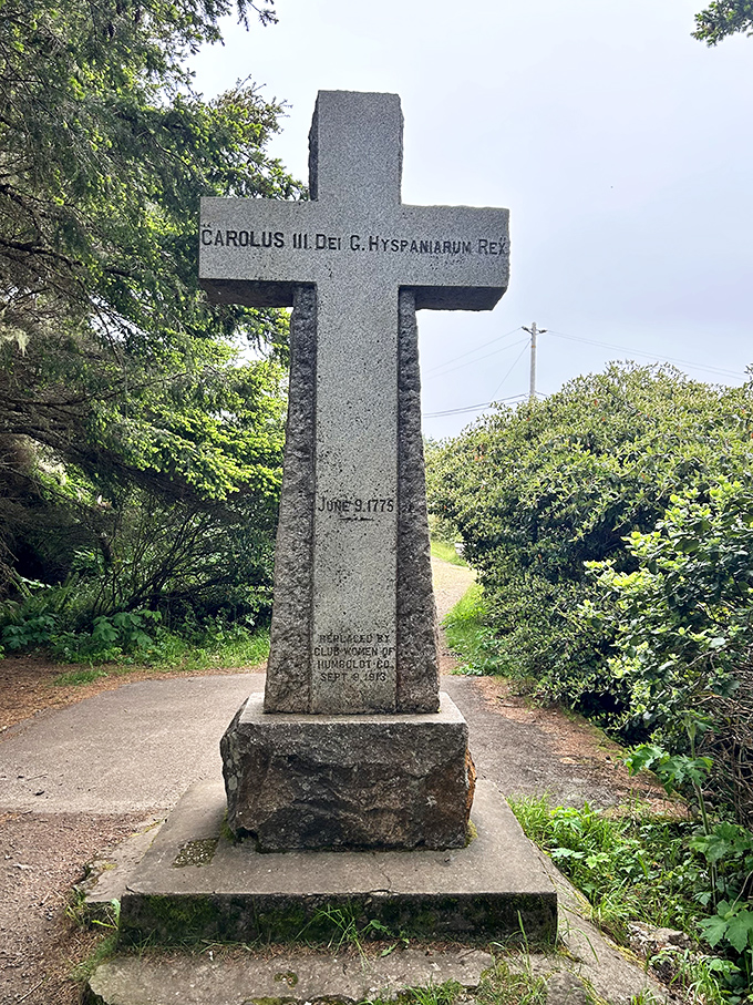 This stone cross commemorates Trinidad's Spanish history, standing stoically among coastal greenery like a sentinel from another time.