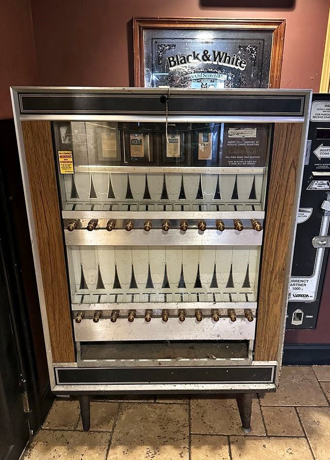 A vintage cigarette machine stands as a nostalgic sentinel, reminding us of tavern days past while we enjoy its present incarnation.