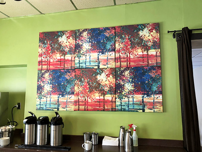 Vibrant artwork splashes color across green walls, giving early risers something beautiful to contemplate between coffee sips.