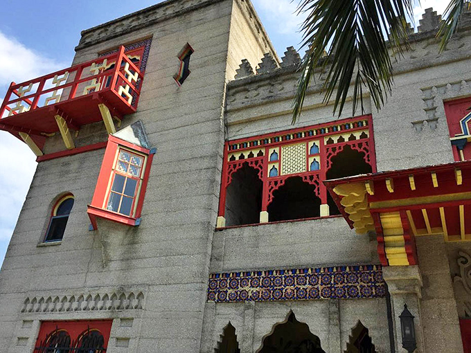 The castle's exterior details reveal themselves in layers&mdash;geometric cutouts, colorful tiles, and those signature red accents against concrete that's withstood over a century of Florida weather.