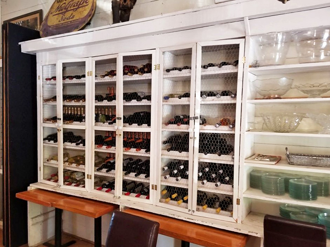 Wine bottles standing at attention behind chicken wire &ndash; rustic storage meets sophisticated selection in this charming display cabinet.
