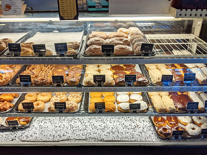 The display case—a museum of carbohydrates where every shelf tells a different delicious story and decisions become gloriously impossible.