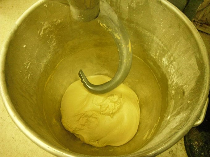 The industrial mixer&mdash;the unsung hero of the bakery world&mdash;kneading dough with the mechanical persistence that human arms could never match.