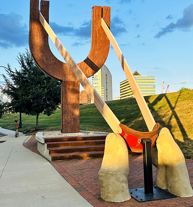 Golden hour bathes The Slingshot in warm light, highlighting the craftsmanship of its wooden frame against the grassy hill behind.