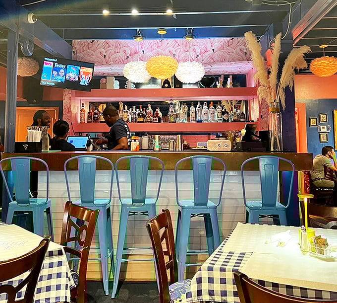 The bar area pops with turquoise chairs against pink walls, proving that breakfast cocktails taste better when surrounded by colors that wake you up faster than caffeine.