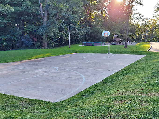 Basketball court where kids discover that "going viral" once meant being really good at H-O-R-S-E, not collecting likes on TikTok.