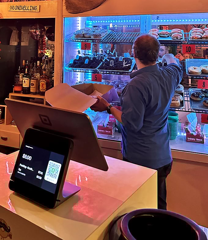 Behind the counter, fresh donuts await their destiny in illuminated display cases. The hardest part is choosing just one.