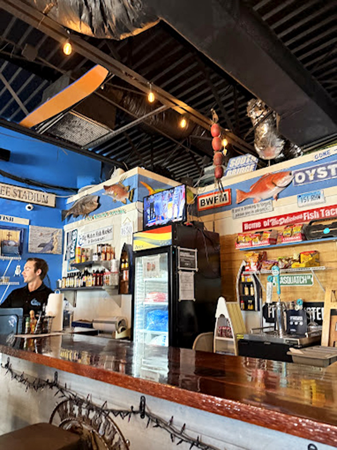 Behind the counter where seafood magic happens. The blue walls and mounted fish create the perfect backdrop for culinary maritime adventures.