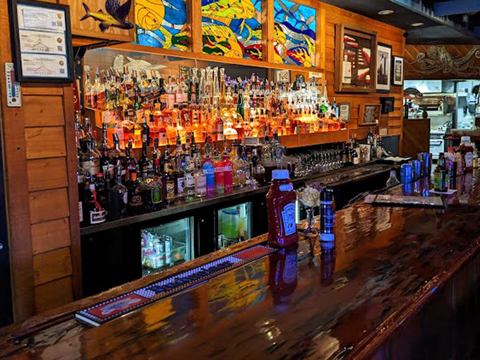 A bar stocked like a pirate's treasure chest, with stained glass fish swimming overhead. Liquid gold for thirsty seafood lovers!