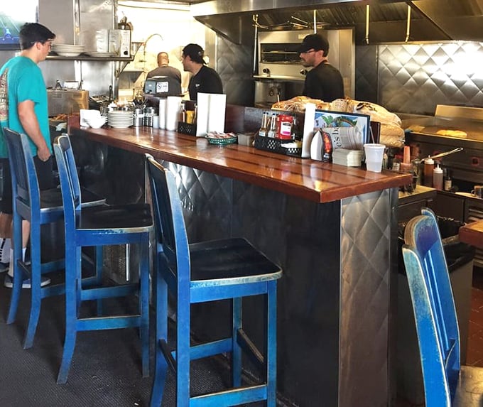 The blue counter stools aren't just seating&mdash;they're front-row tickets to culinary theater where seafood is the star and hunger always gets a happy ending.