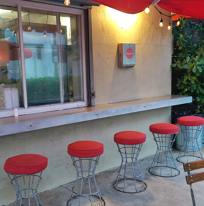 Bar seating that invites conversation. These fire-engine red stools are perfect perches for solo diners or those waiting for their hot dog masterpieces.