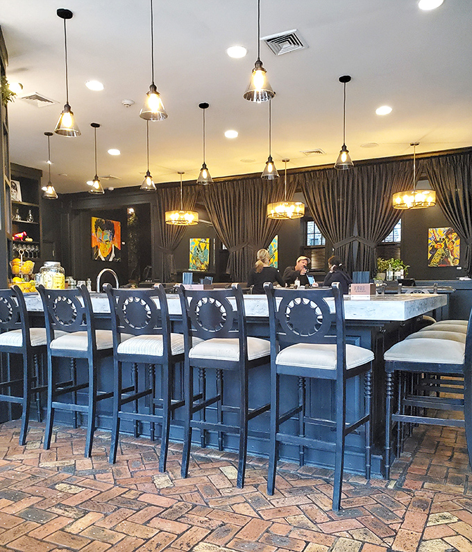 The marble-topped bar with its elegant blue chairs isn't just seating – it's front-row tickets to the culinary theater of Bridget's.