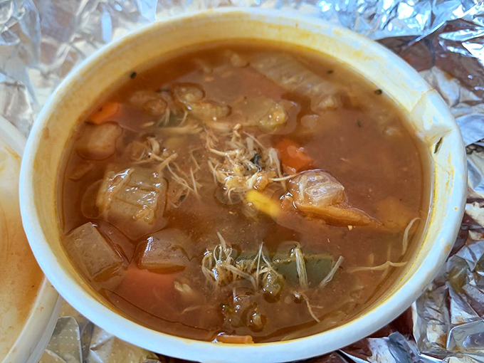 Maryland crab soup, a spicy, tomato-based treasure hunt. Each spoonful reveals vegetables and crab meat in a broth that tastes like the Chesapeake distilled.