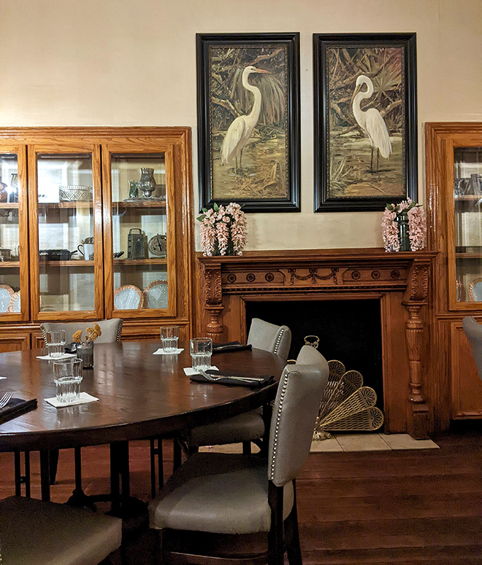 Elegant heron artwork watches over diners like silent sentinels of Lowcountry tradition, while the warm wood tones create an atmosphere of refined comfort.