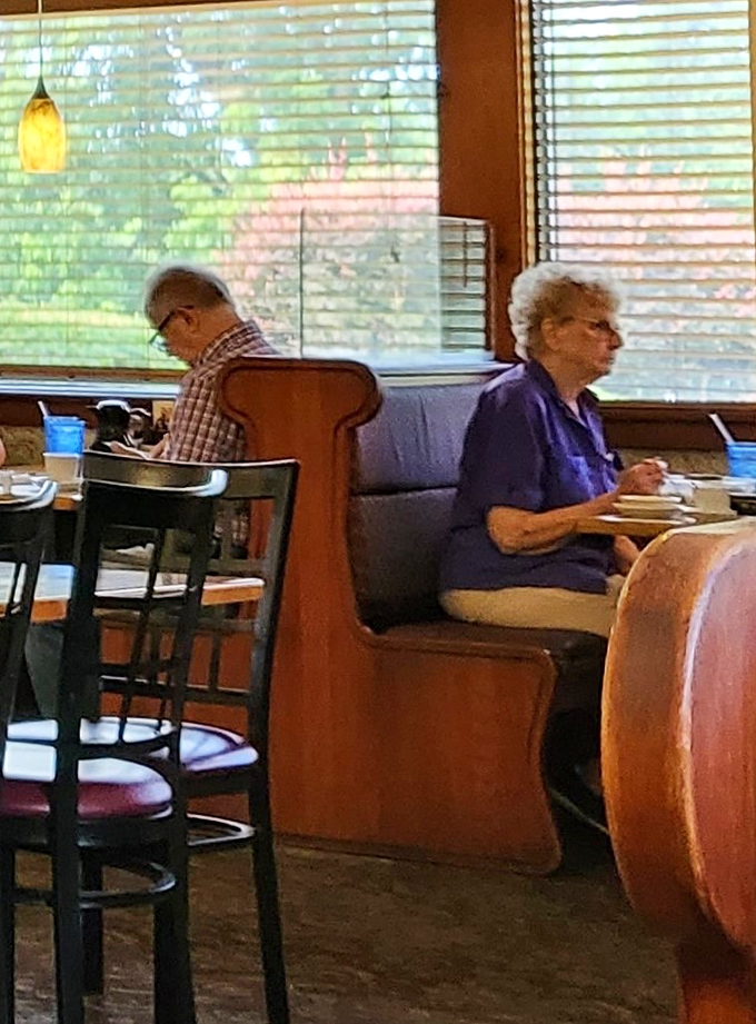 Regular customers in their natural habitat—the corner booth where they've likely been solving the world's problems over coffee for decades.